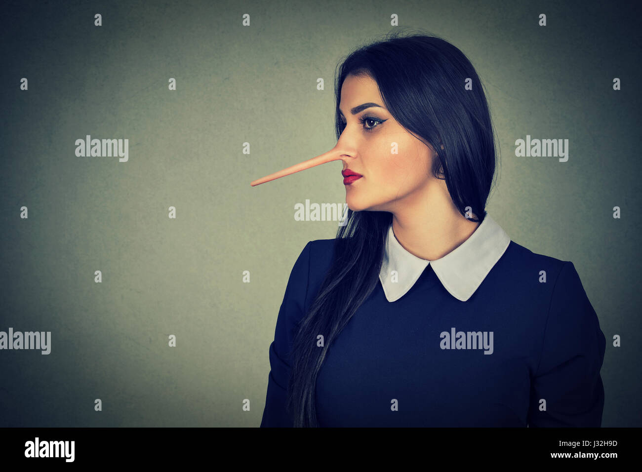 Woman with long nose isolated on grey wall background. Liar concept ...