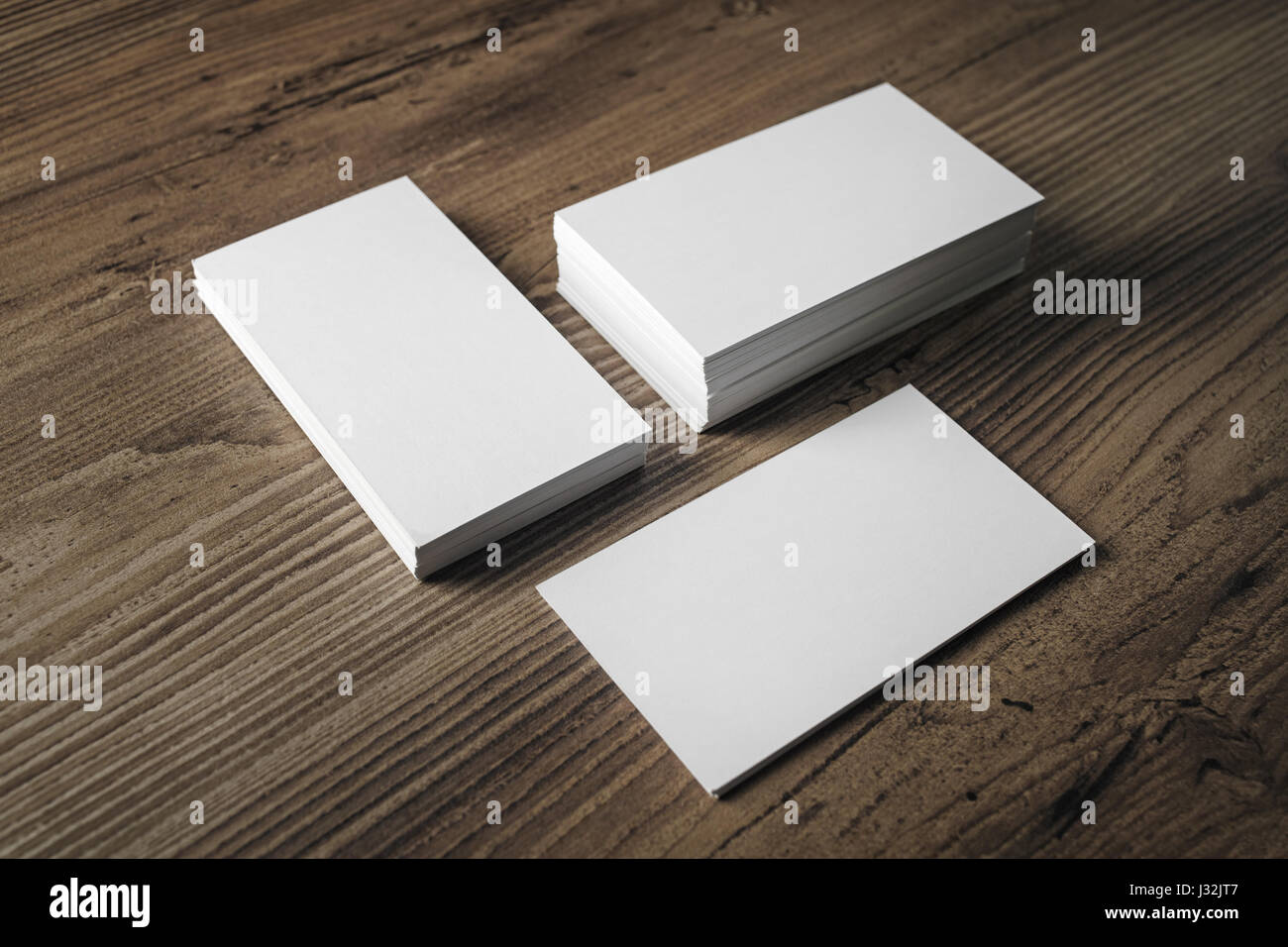 Stacks of blank name cards on wooden table background. Template for ...