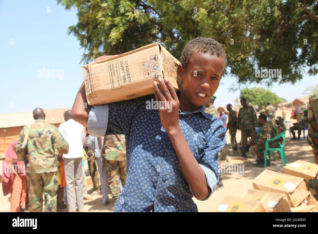 A young boy from Goobweyn Village carries food distributed by the ...