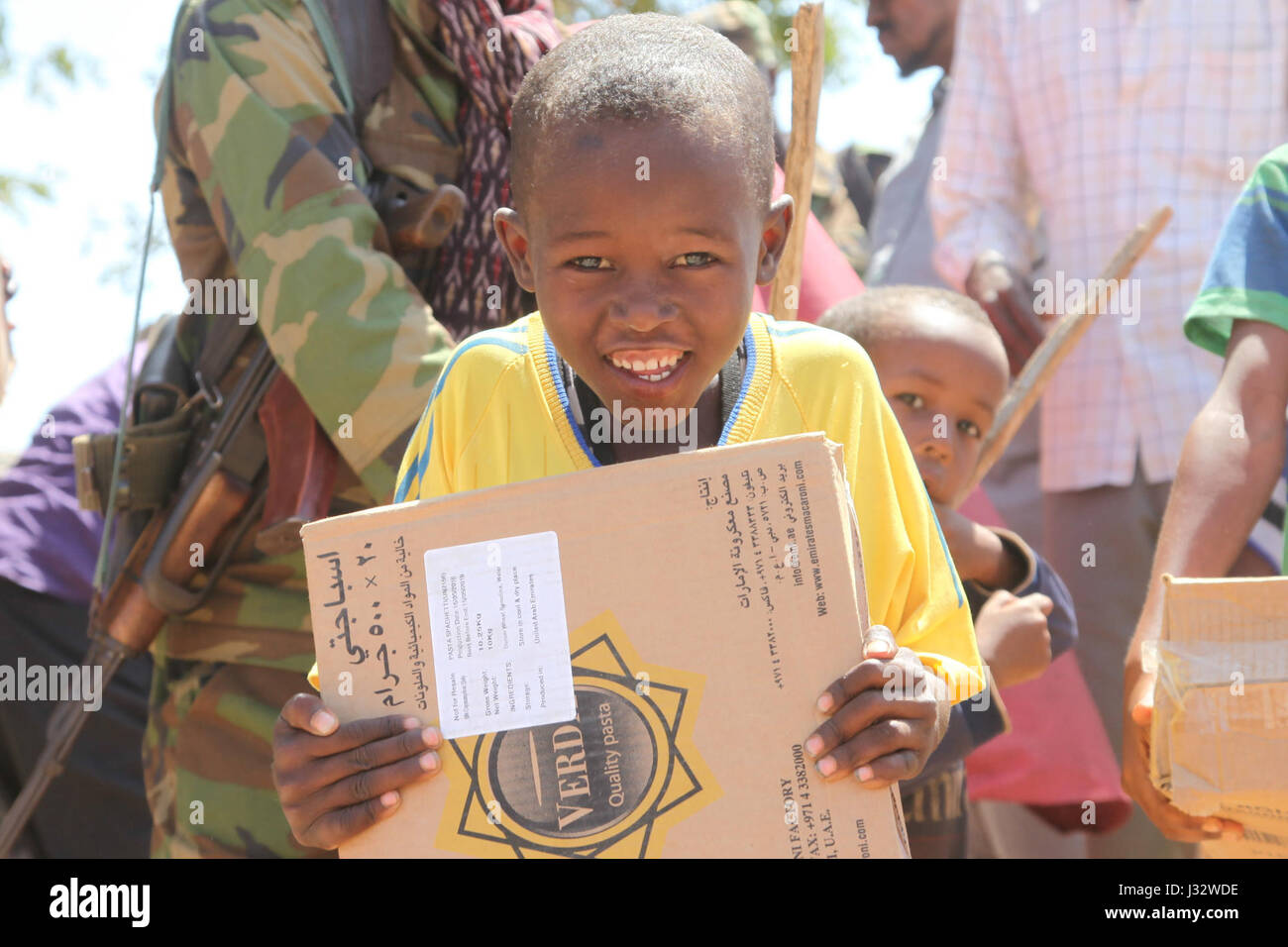 A young boy in Goobweyn, Somalia, is receiving food aid distributed by ...