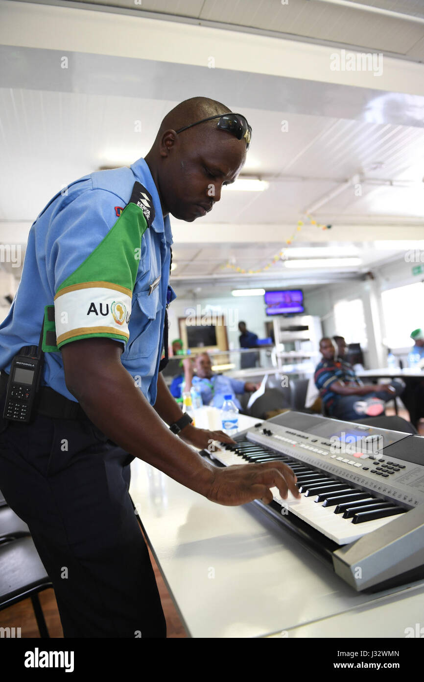 An AMISOM police officer performs on a piano during a medal ceremony ...