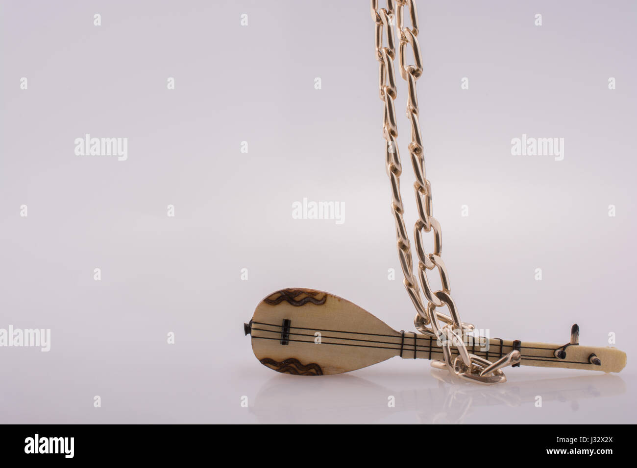 Chain tied to a Turkish musical instrument saz on a white background ...