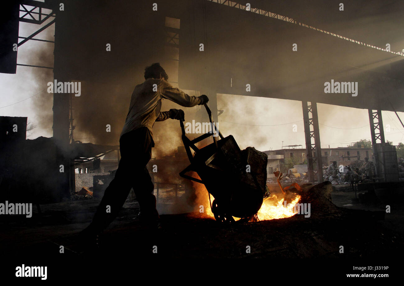 Pakistani laborers work at an iron factory on the eve of International ...