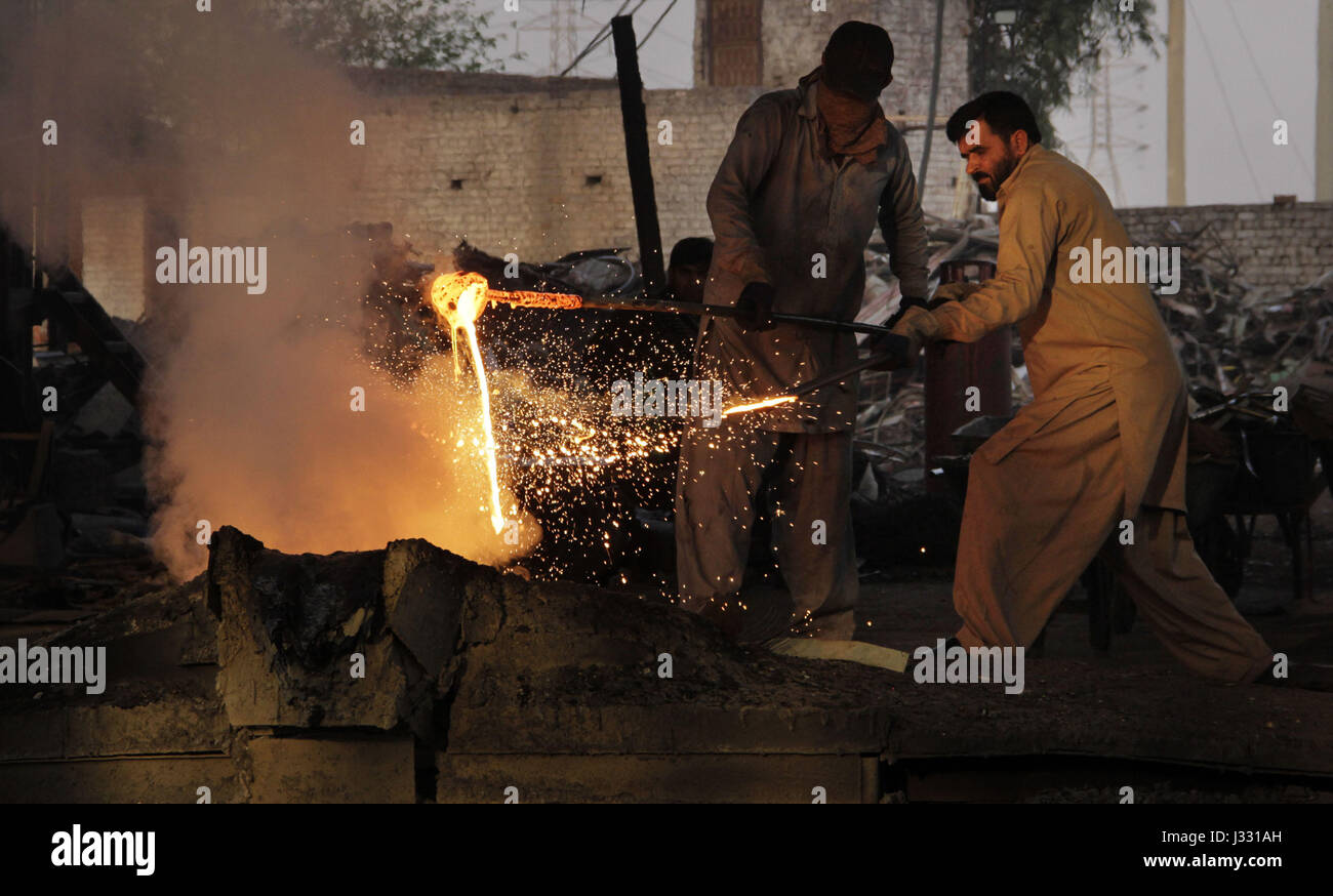 Pakistani laborers work at an iron factory on the eve of International ...