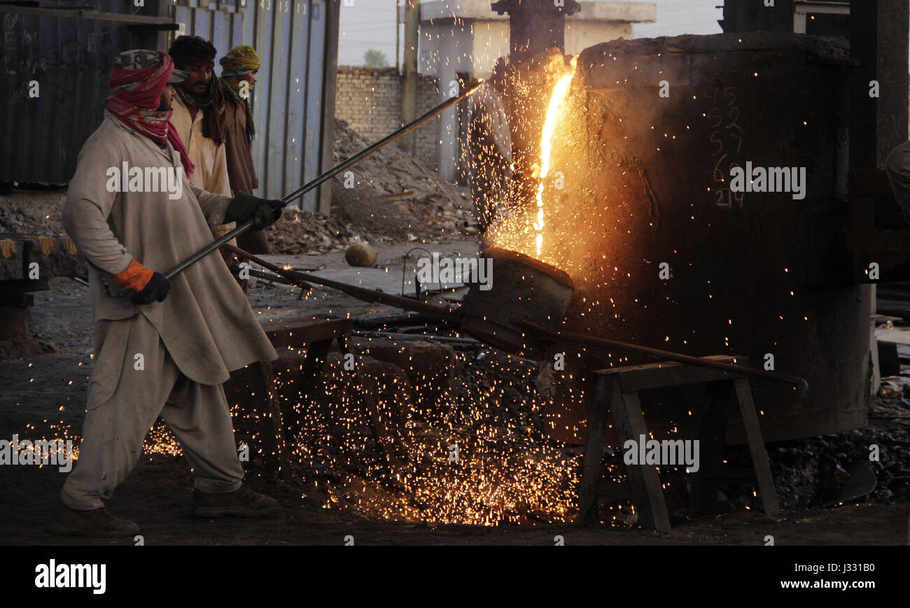 Pakistani laborers work at an iron factory on the eve of International ...