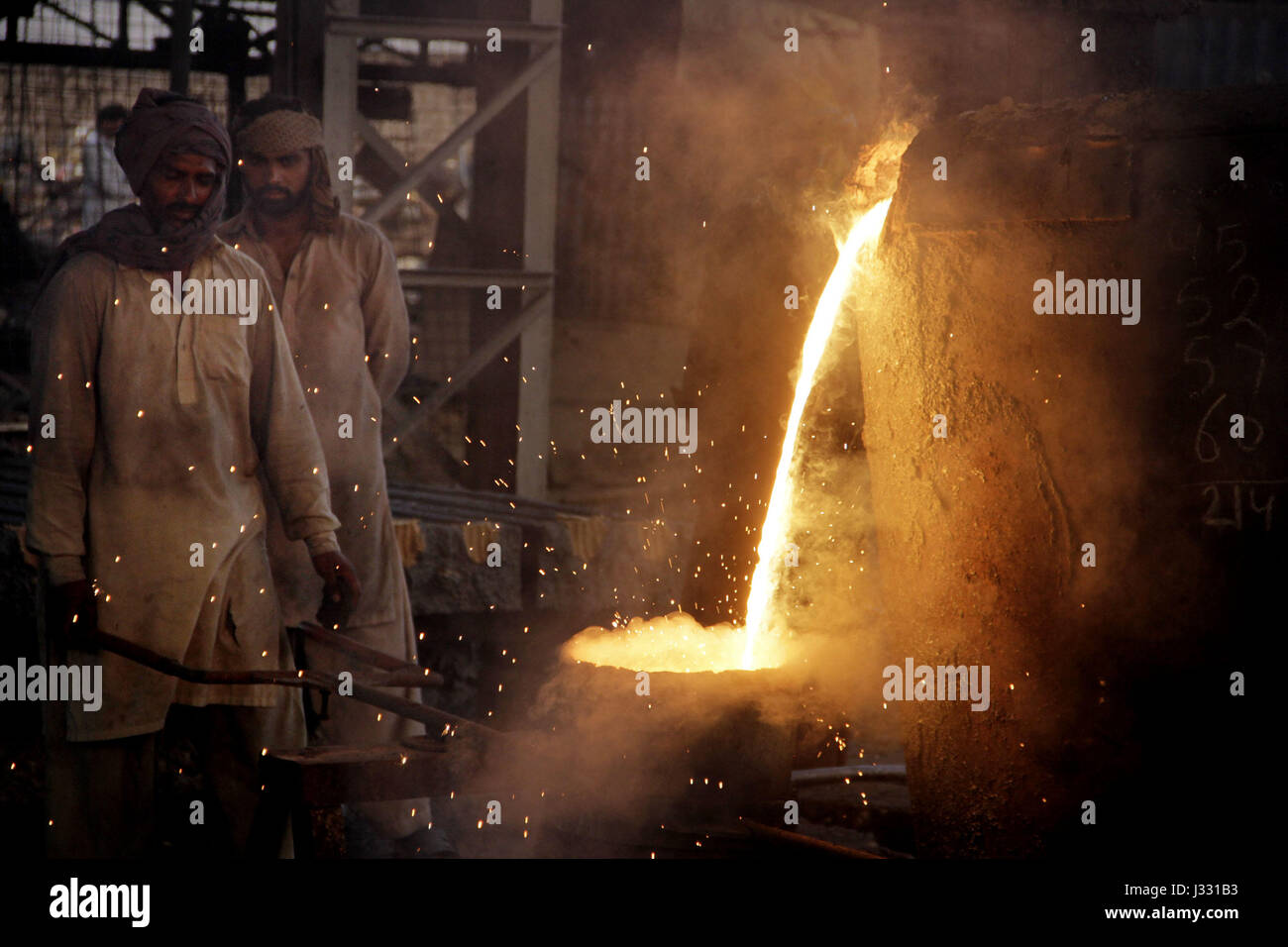Pakistani laborers work at an iron factory on the eve of International ...