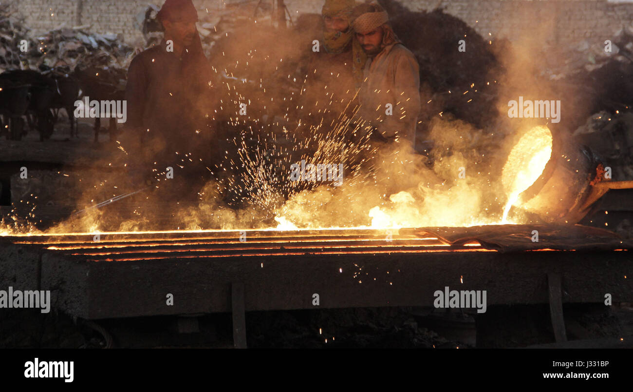 Pakistani laborers work at an iron factory on the eve of International ...