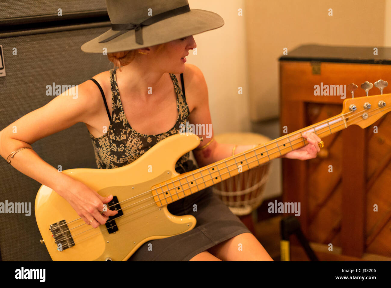 Young female musician playing a bass guitar Stock Photo - Alamy