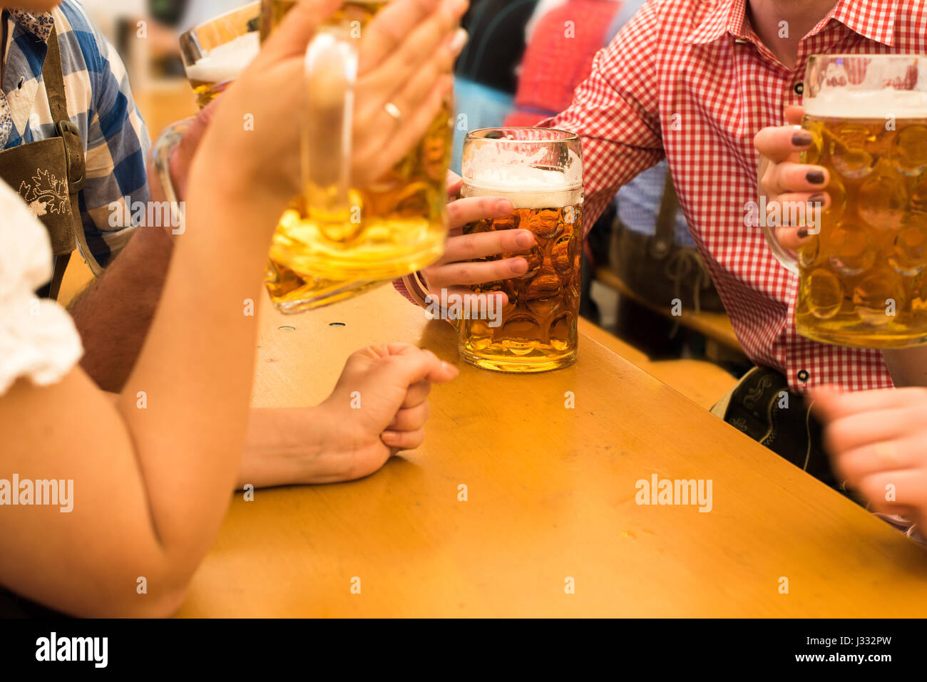 Girls in traditional Dirndl dresses are drinking beer and having fun ...