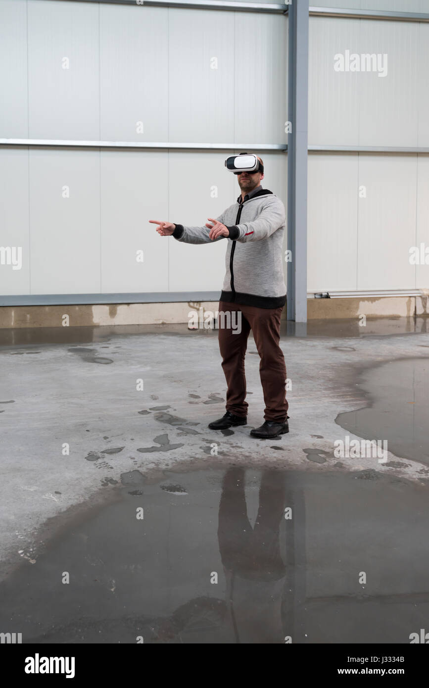 Architect with VR visor exploring industrial building environment ...