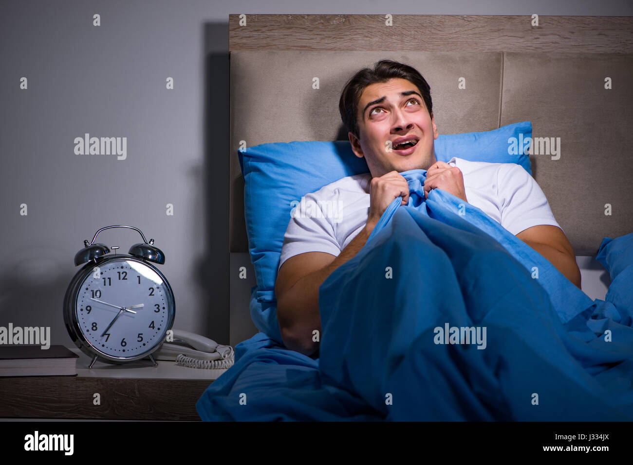 Young man scared in bed Stock Photo - Alamy