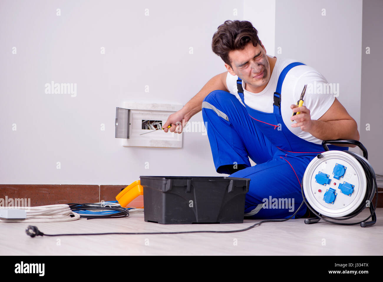 Funny Man doing electrical repairs at home Stock Photo - Alamy