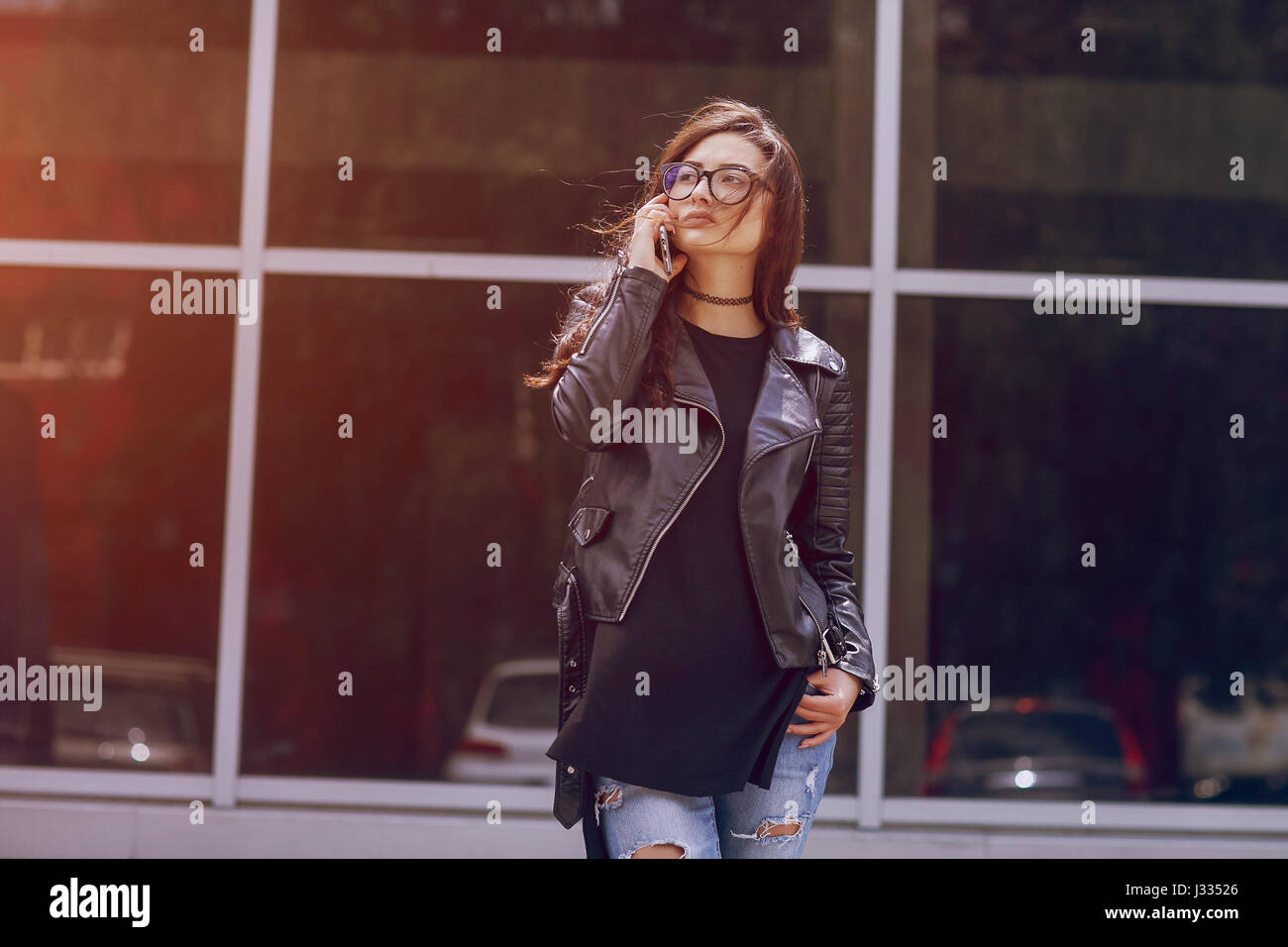 stylish young model walk in the street and pose for a photo on a Sunny ...