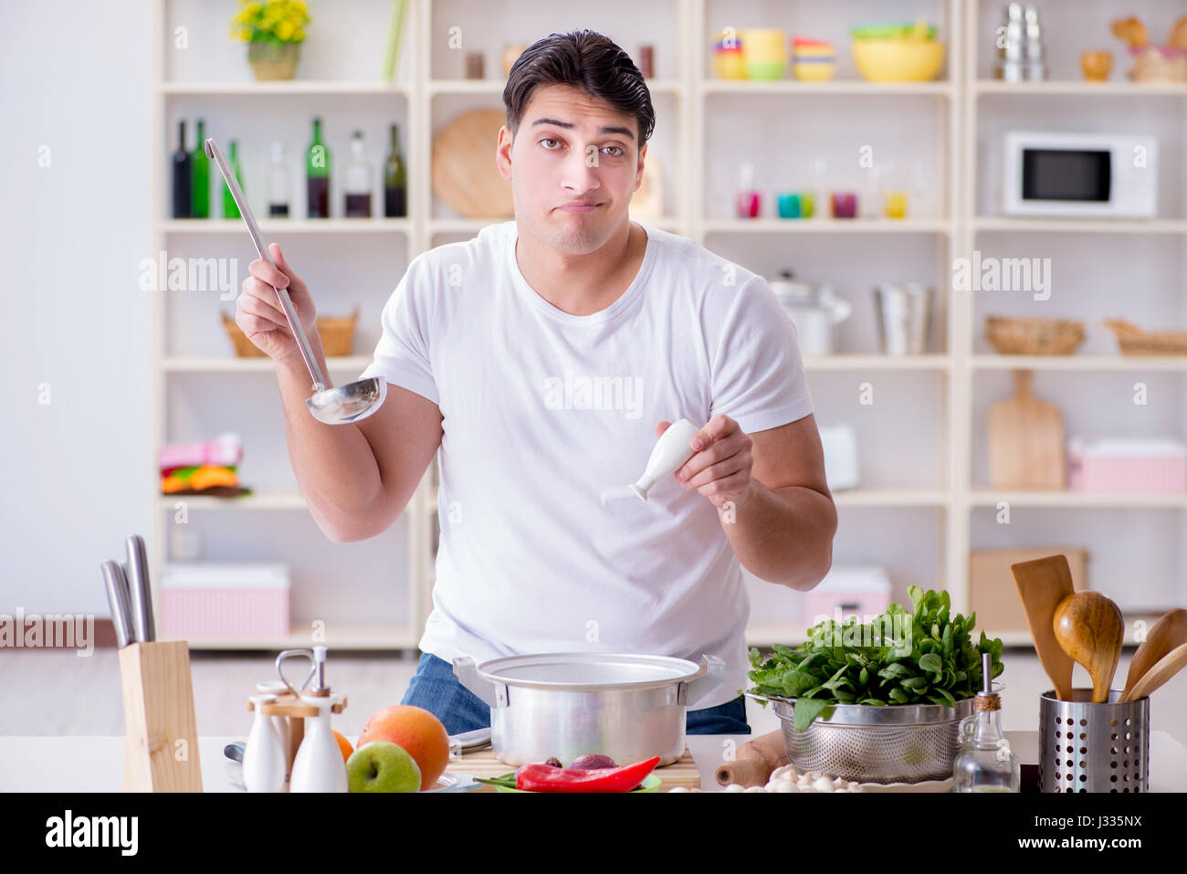 Young male cook working in the kitchen Stock Photo - Alamy