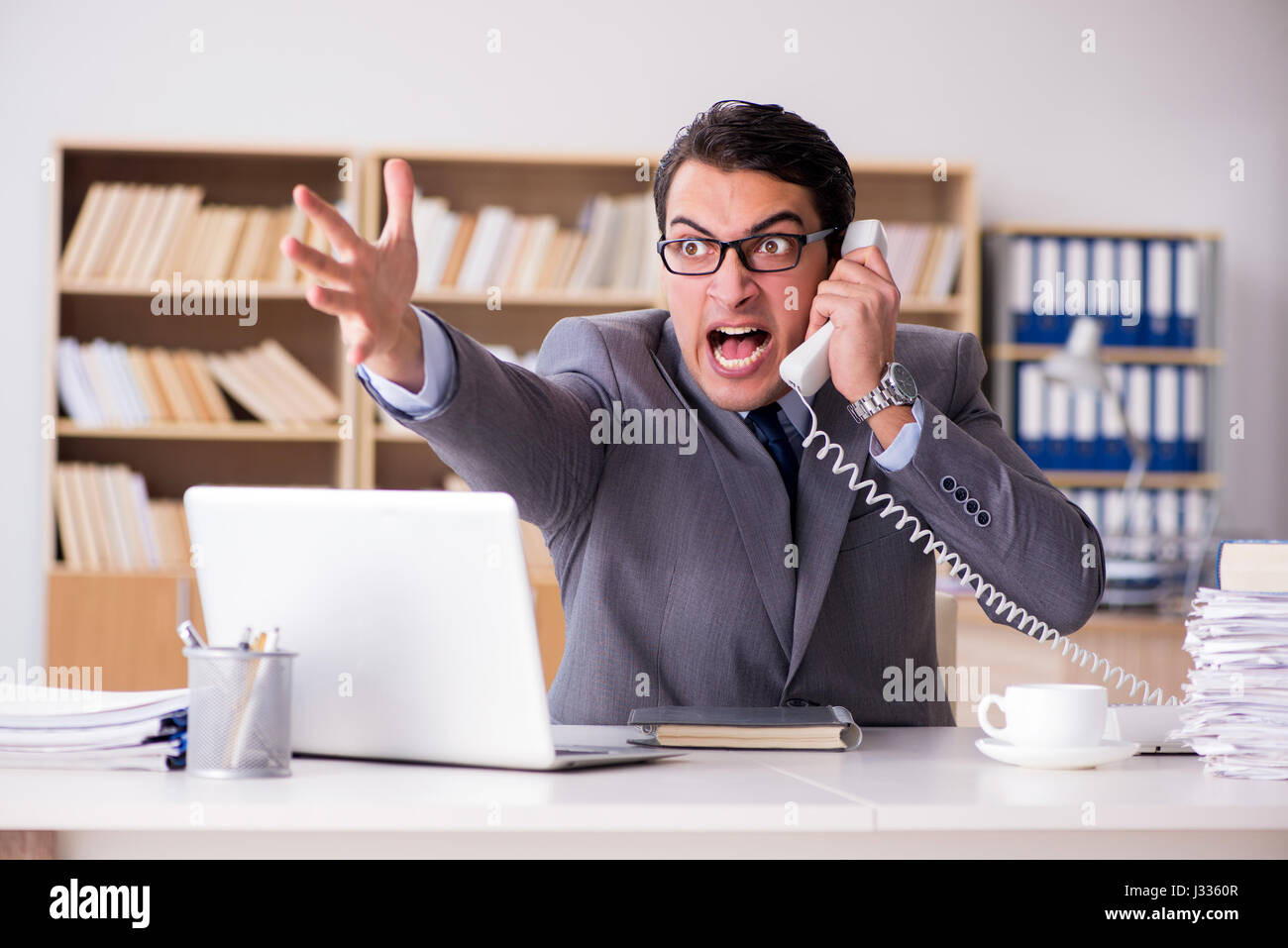 Angry businessman working in the office Stock Photo - Alamy