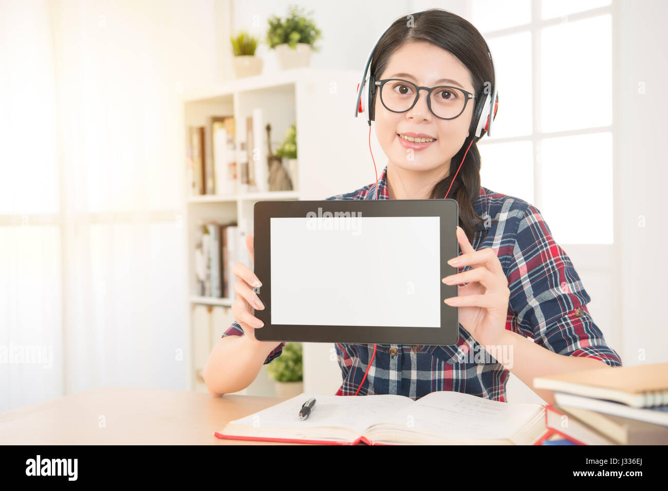 Student studying with digital pad and showing blank screen on a desktop ...