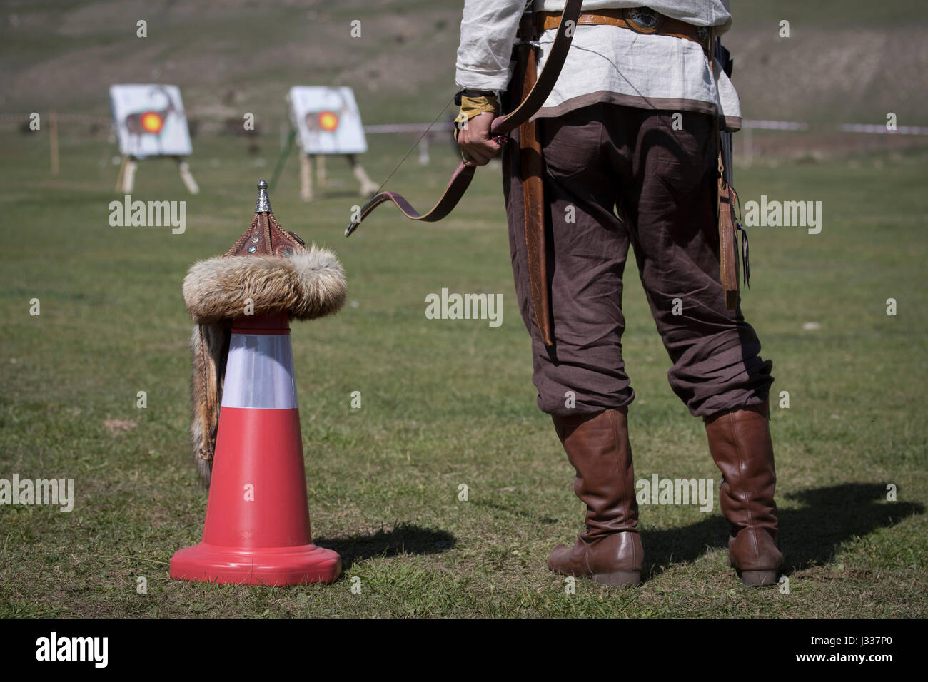 An archer from Hungary perches his hat on a traffic cone during an ...