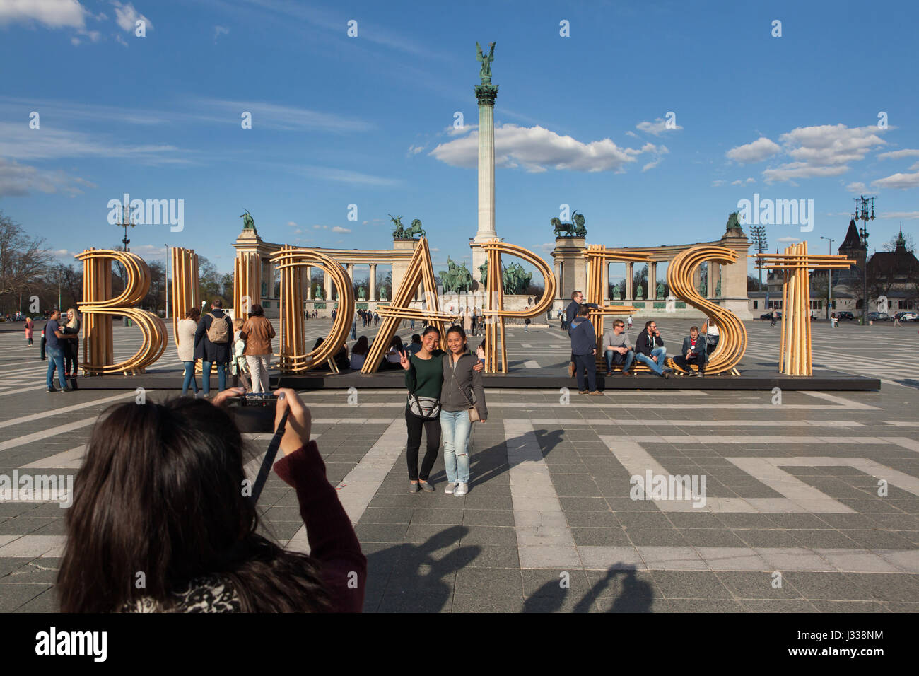 Tourists take photographs posing in front of the Budapest Sign ...