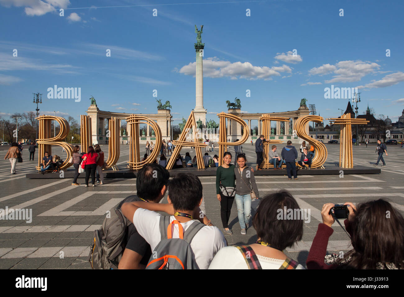 Tourists take photographs posing in front of the Budapest Sign ...