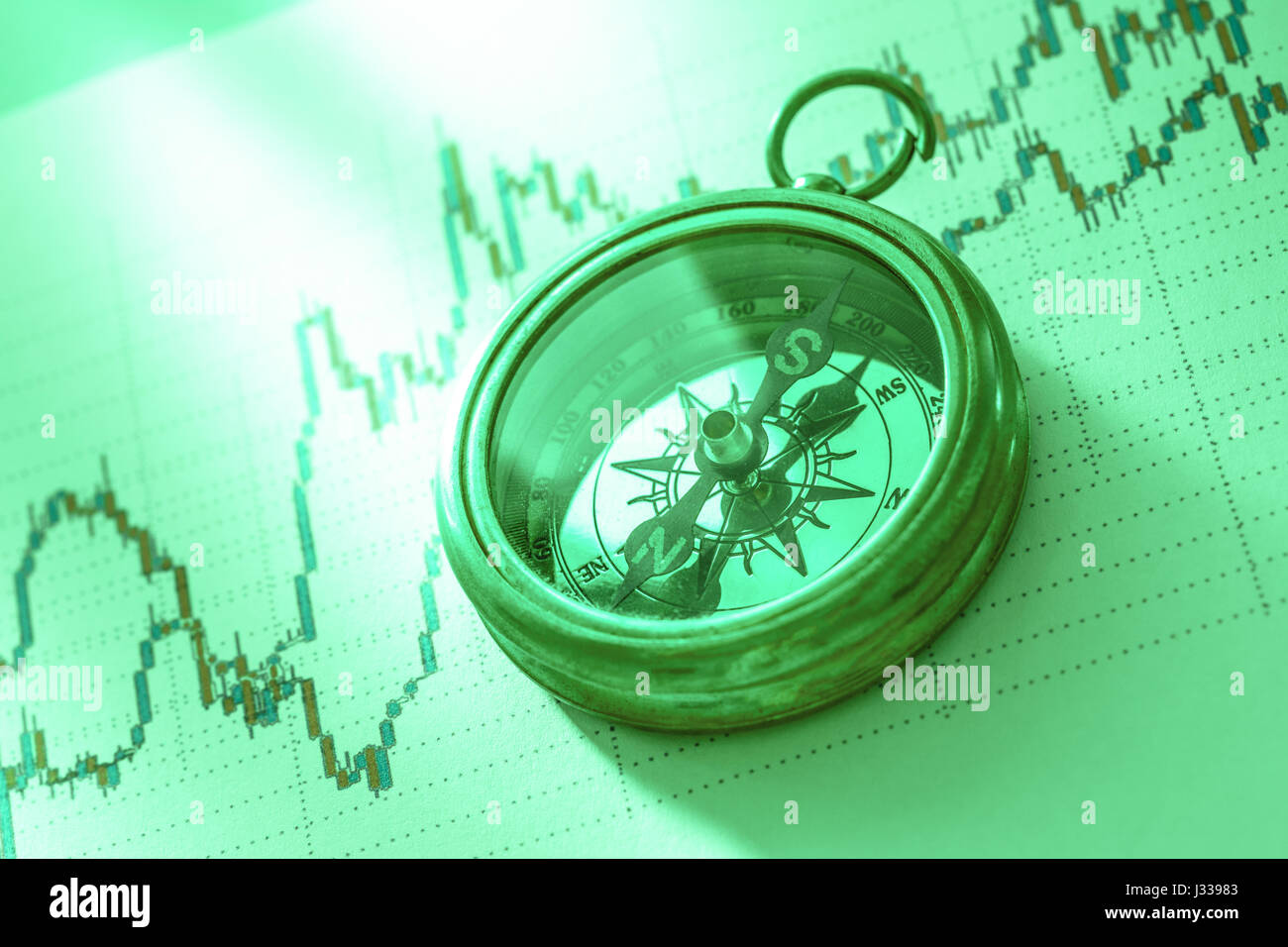 Compass on stock market data chart in closeup Stock Photo - Alamy