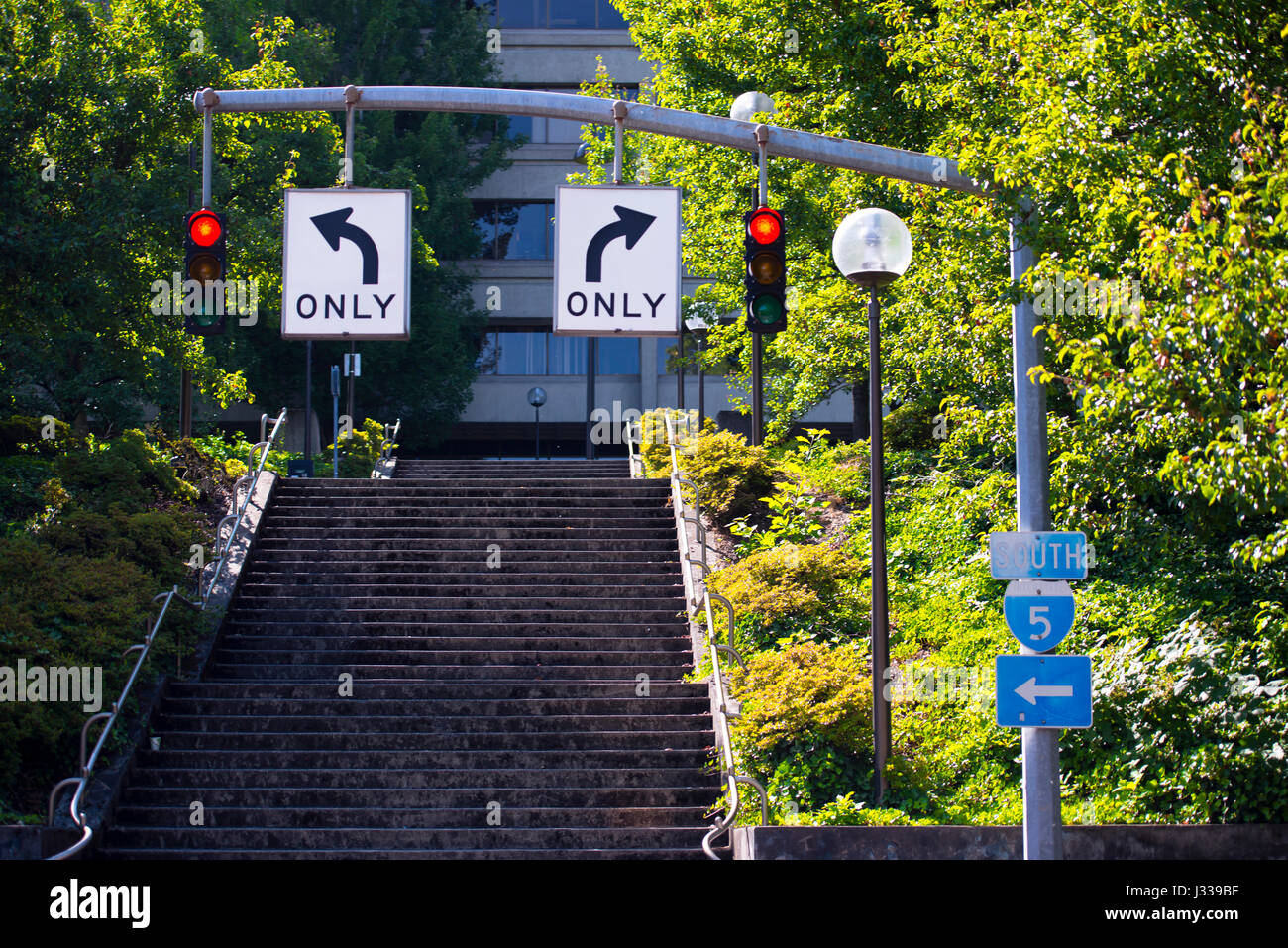 Two traffic lights with a red light on a pole with travel direction ...