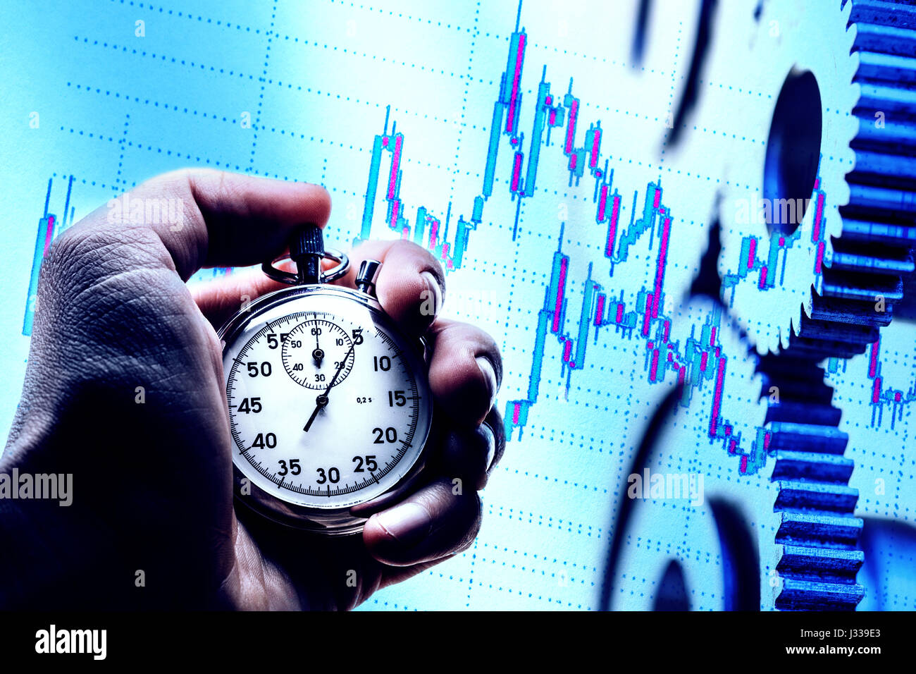 Male hand holding stopwatch on chart of stock market investment trading ...