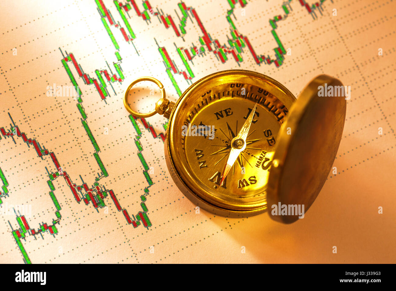 Compass on stock market data chart in closeup Stock Photo - Alamy