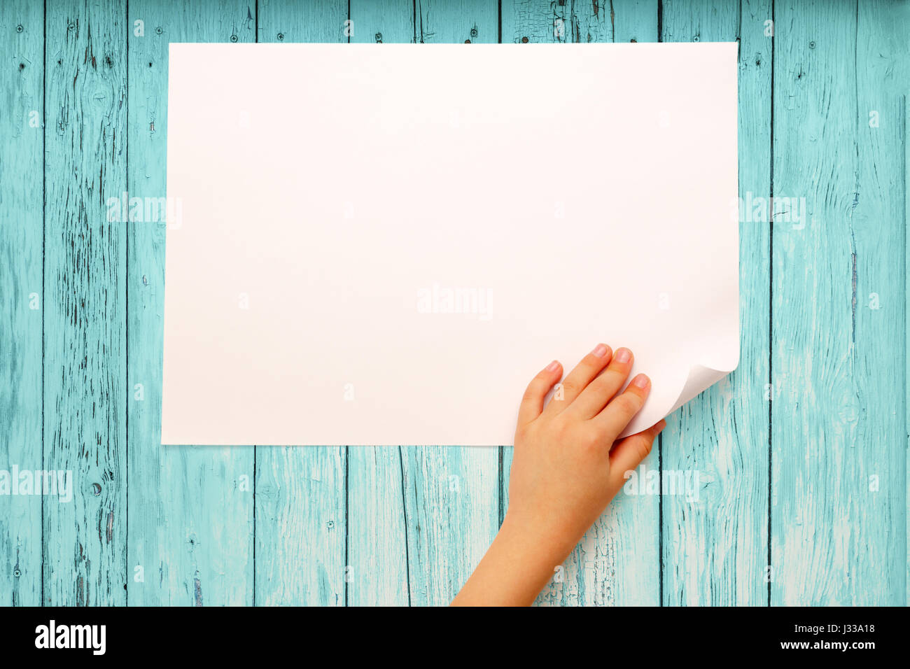 Child's hand turning over sheet of paper Stock Photo - Alamy
