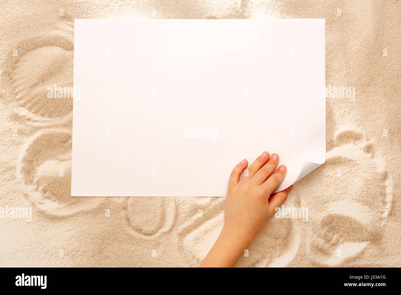Child's hand turning over sheet of paper Stock Photo - Alamy