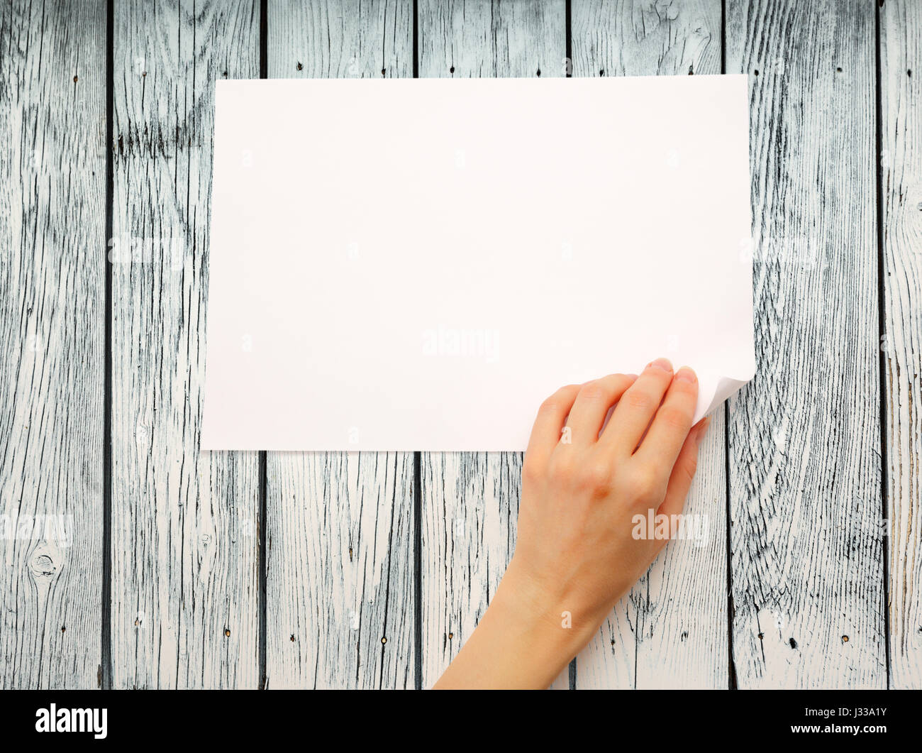 Woman's hand turning over sheet of paper Stock Photo - Alamy
