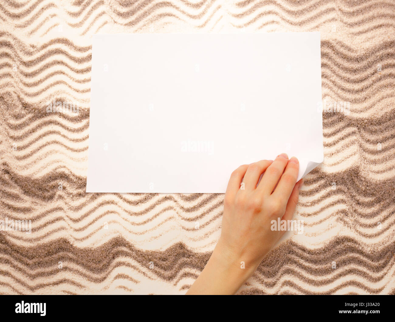 Woman's hand turning over sheet of paper Stock Photo - Alamy