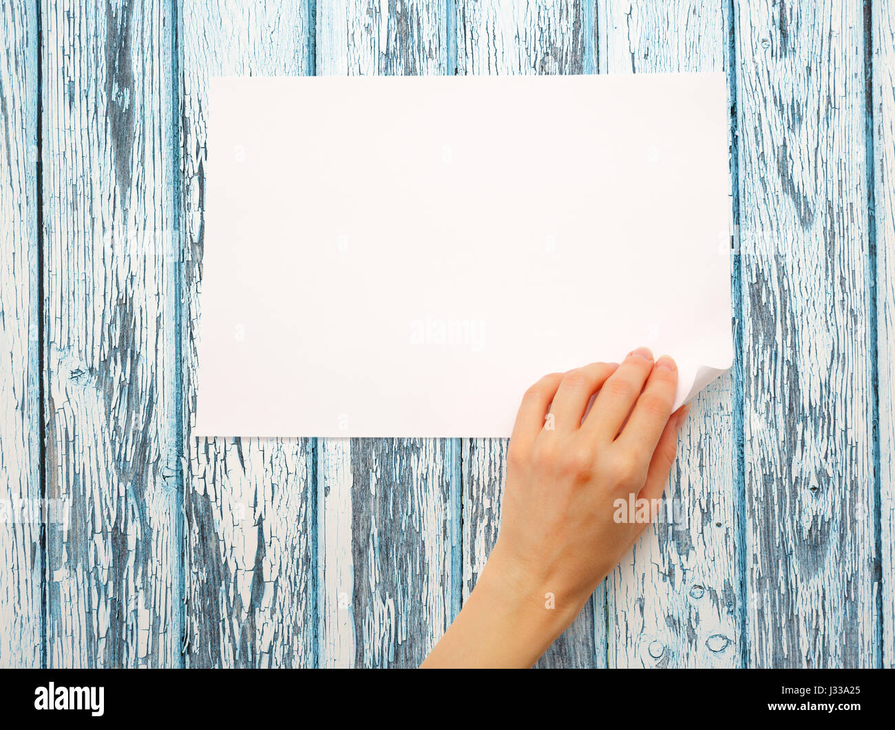 Woman's hand turning over sheet of paper Stock Photo - Alamy