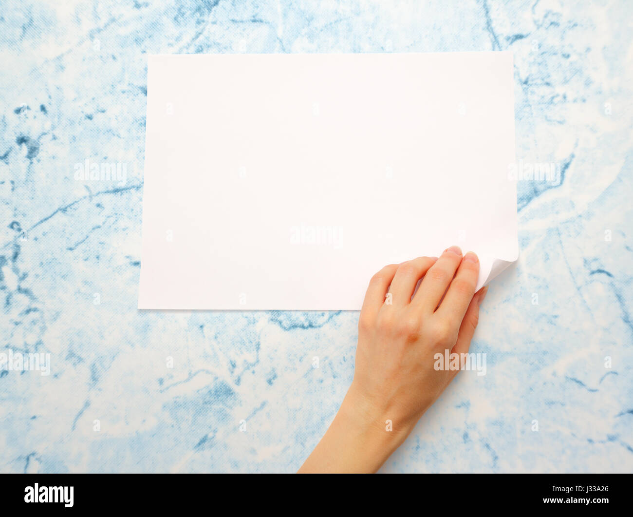 Woman's hand turning over sheet of paper Stock Photo - Alamy