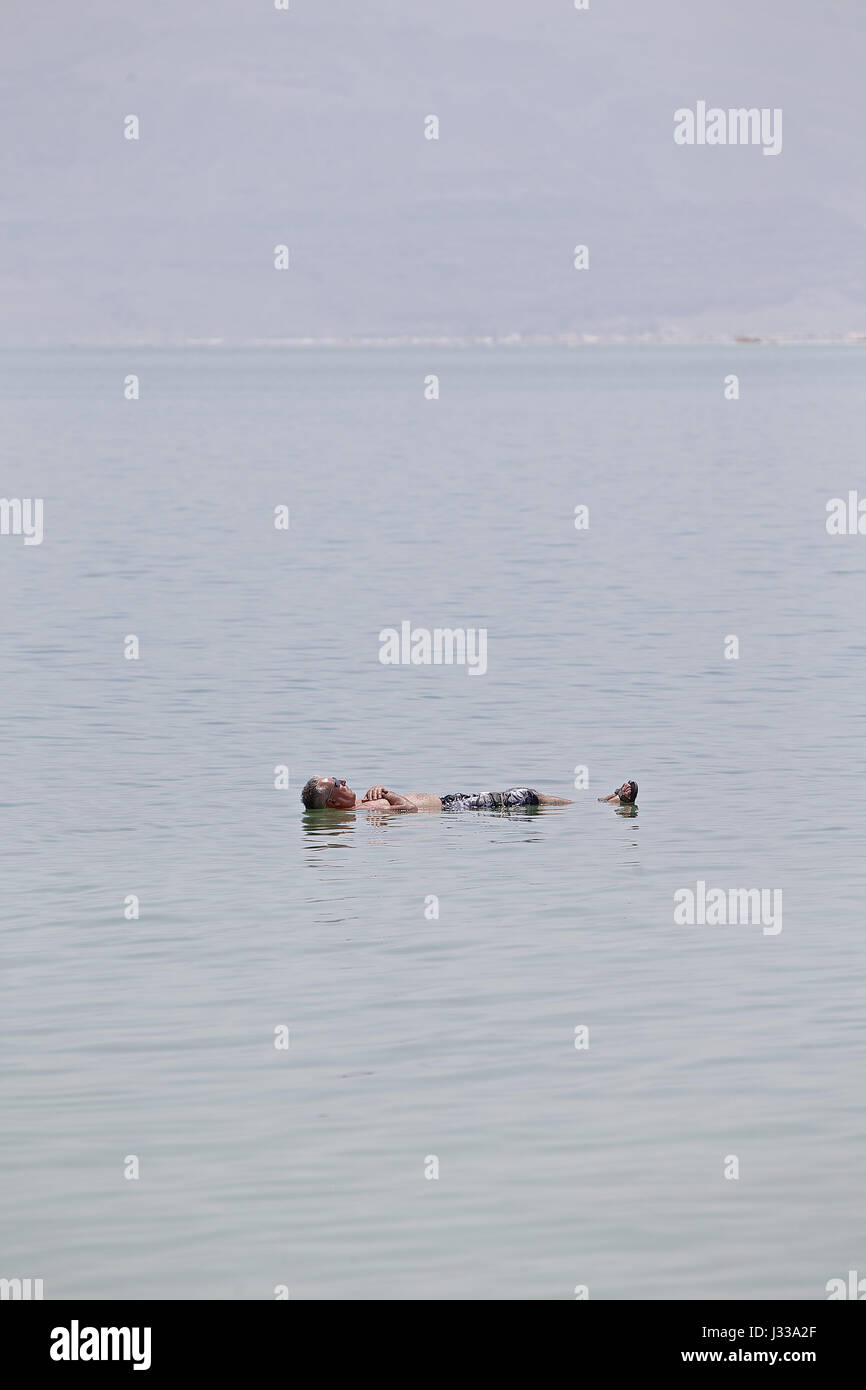 Man floating in the water of the Dead Sea, Masada, Dead Sea, Israel ...