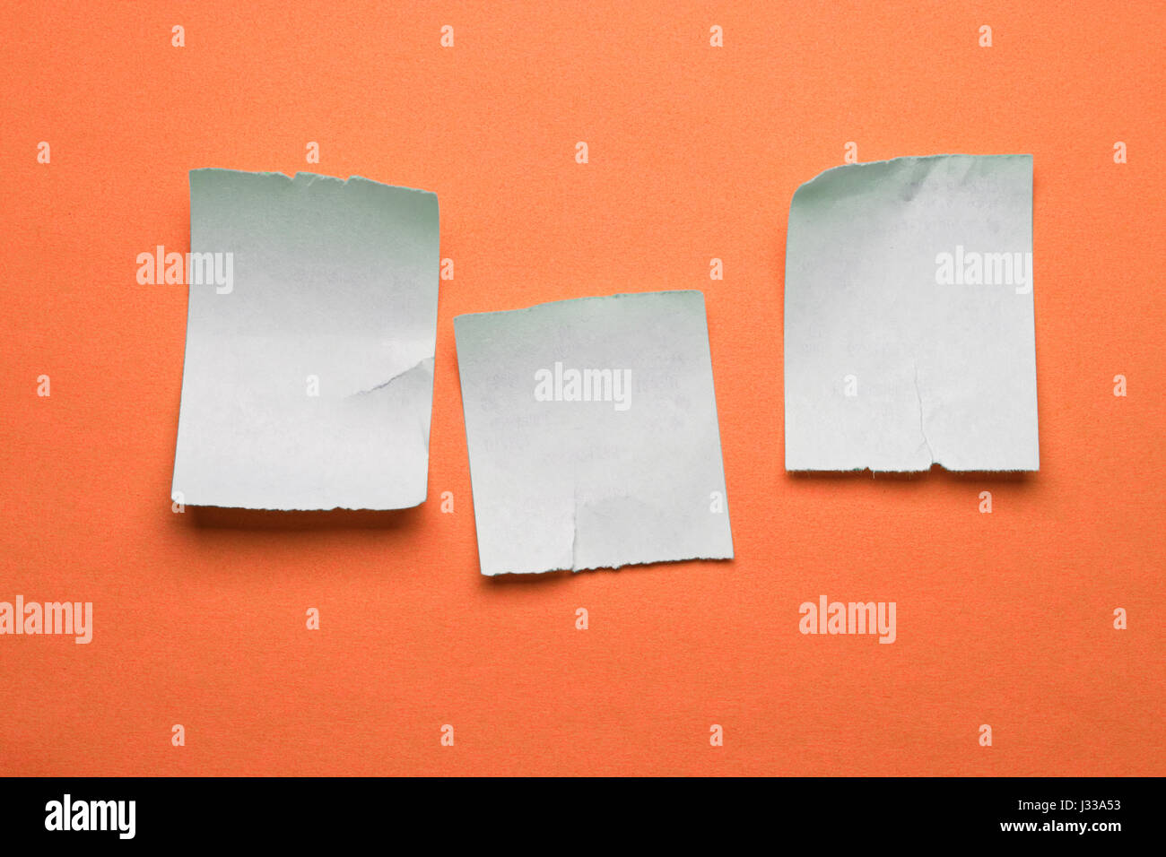 Paper scraps placed on the orange background Stock Photo - Alamy