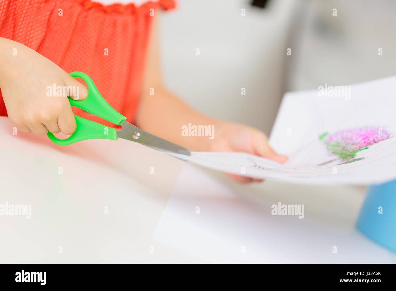 Child's hands cutting paper with scissors closeup Stock Photo - Alamy