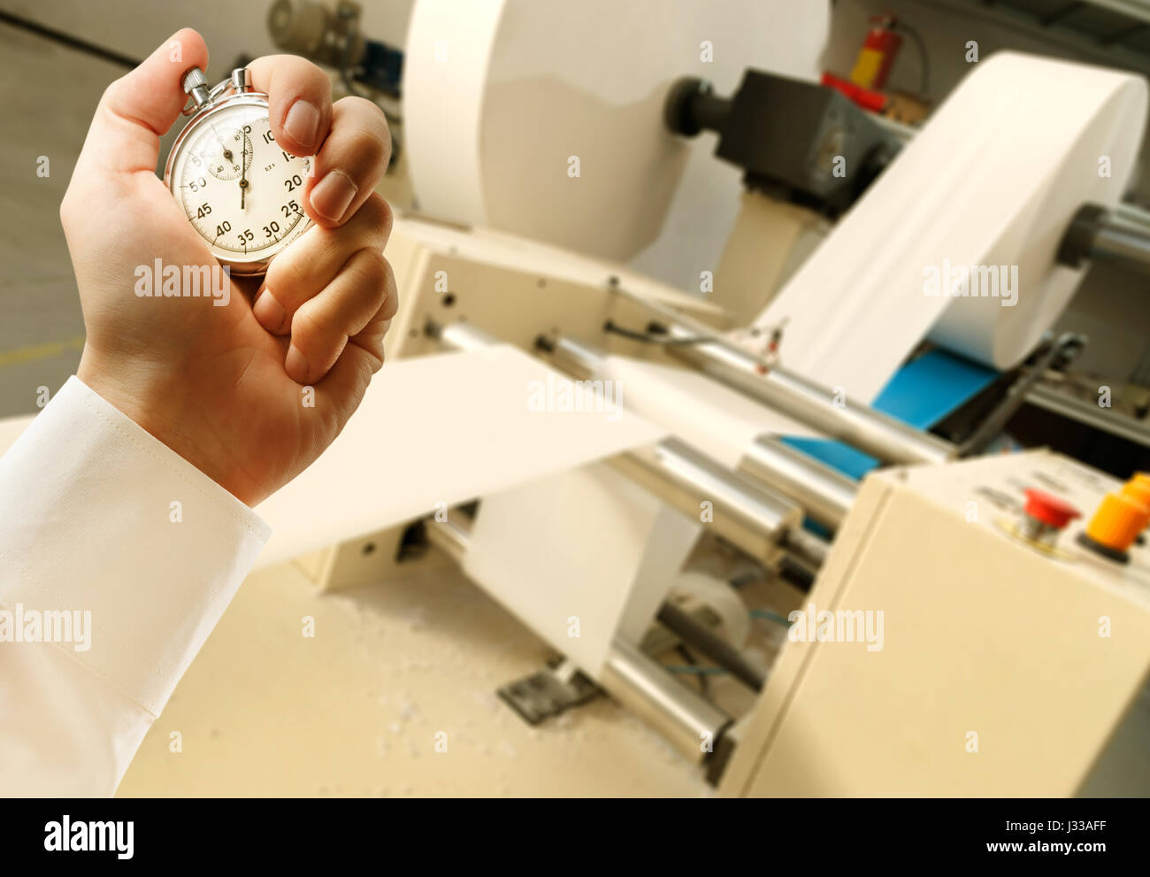 Process of paper products manufacturing and stopwatch in male hand ...