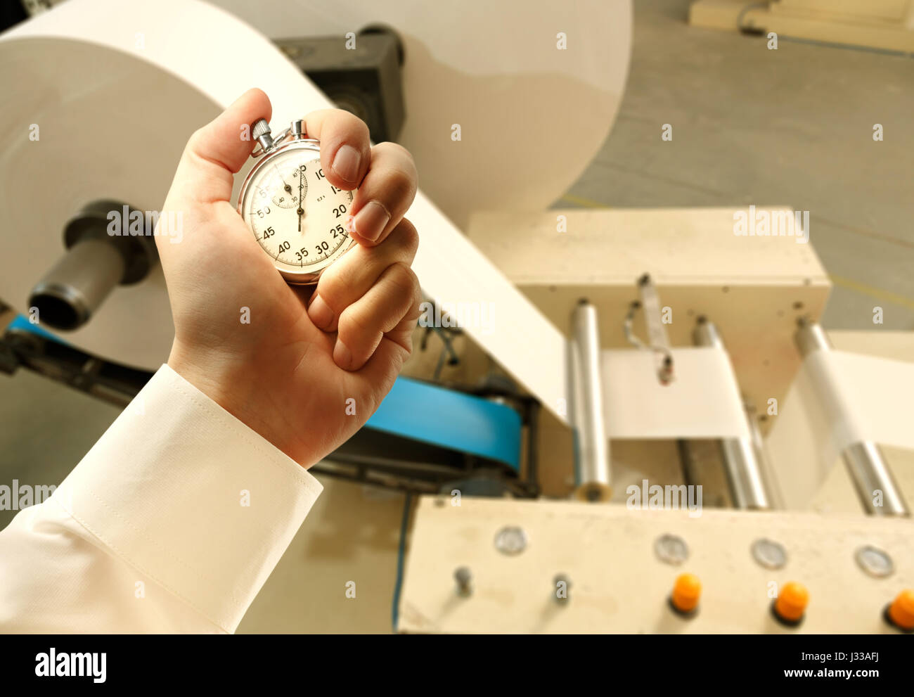 Process of paper products manufacturing and stopwatch in male hand ...