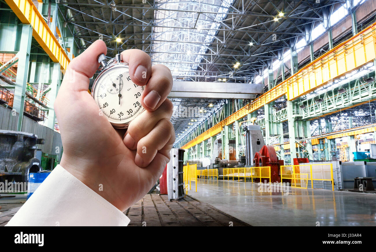 Machine shop of metallurgical works and stopwatch in male hand Stock ...