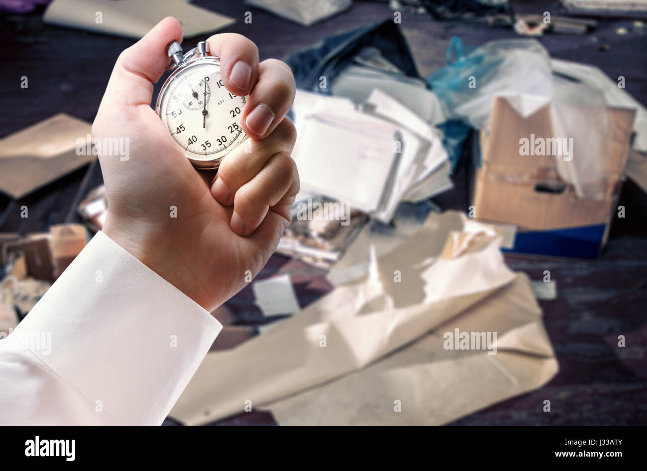 Messy workplace and stopwatch in male hand Stock Photo - Alamy