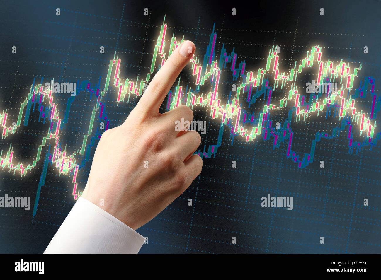 Candlestick chart and pointing forefinger of male hand Stock Photo - Alamy