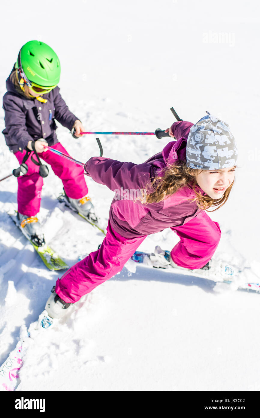 girl pulling a boy along the slope, Pfronten, Allgaeu, Bavaria, Germany ...