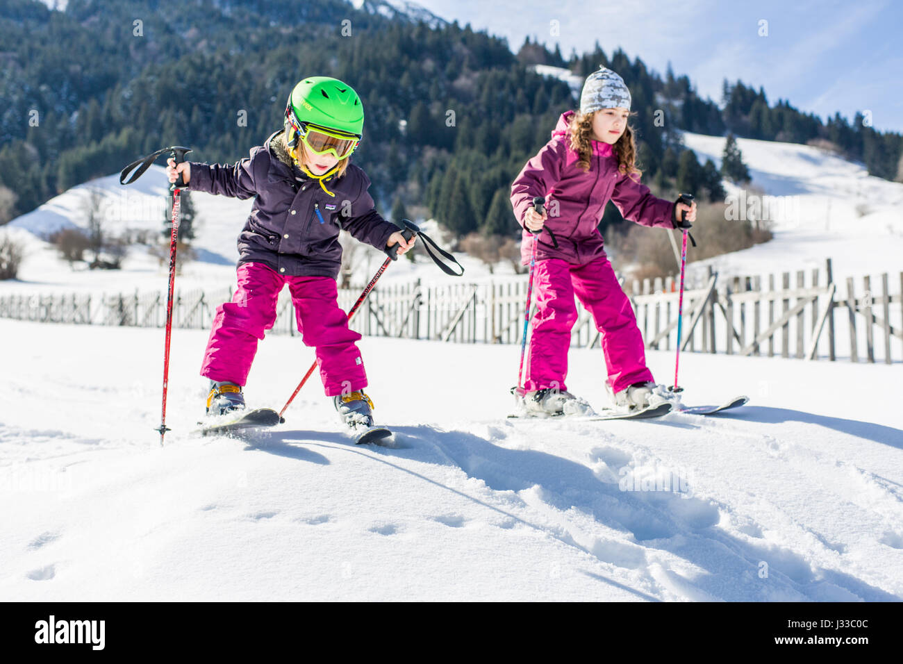 girl and boy skiing on the slope, Pfronten, Allgaeu, Bavaria, Germany ...