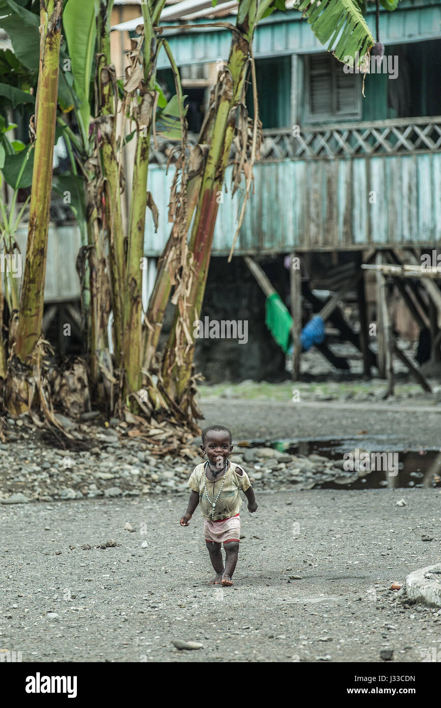 Little child wearing simple clothes walking through a poor area, Sao ...
