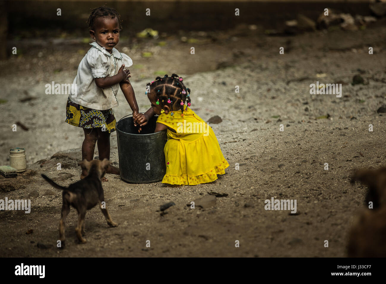 Two little native children washing their hands in a bucket, Sao Tome ...