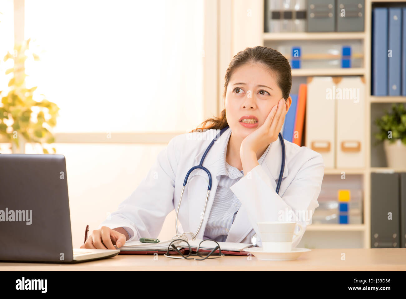 Beautiful young woman doctor suffering from toothache in clinic at ...
