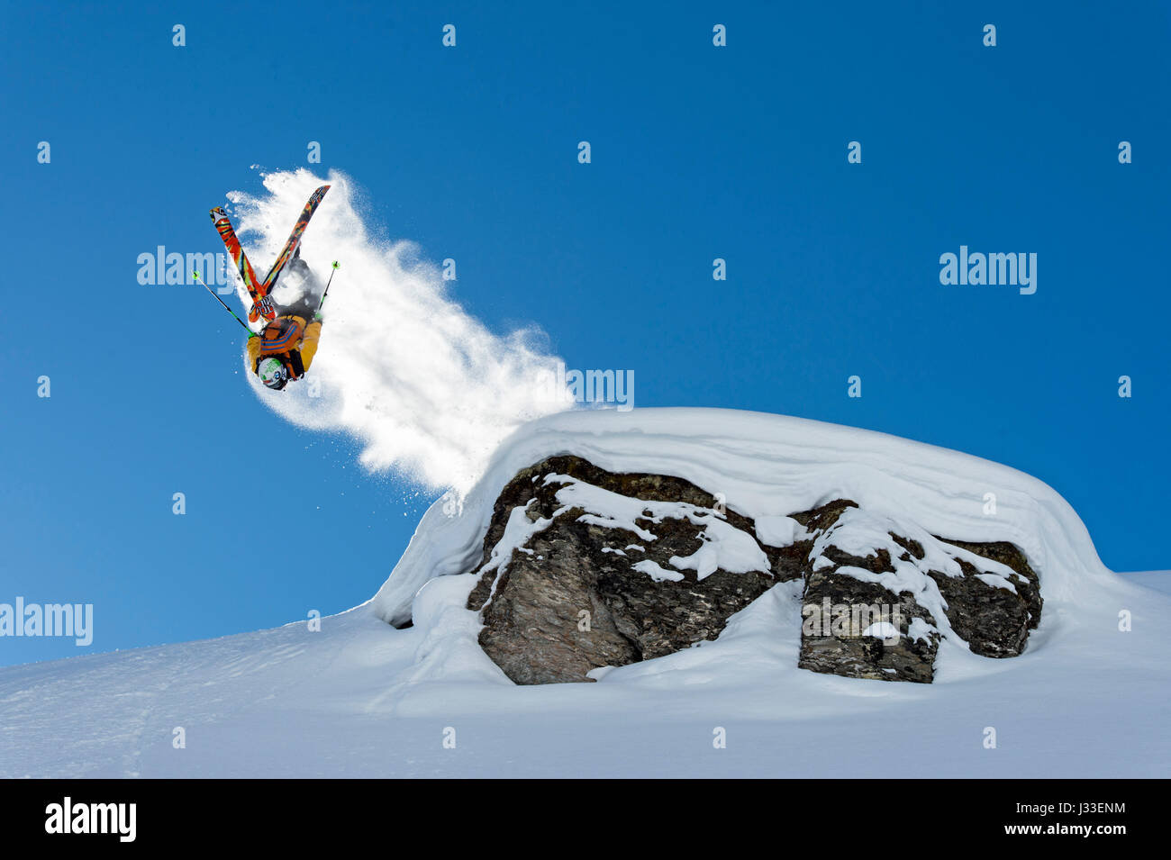 Skier doing a back flip and leaving a snowtail, Hochfuegen, Zillertal ...