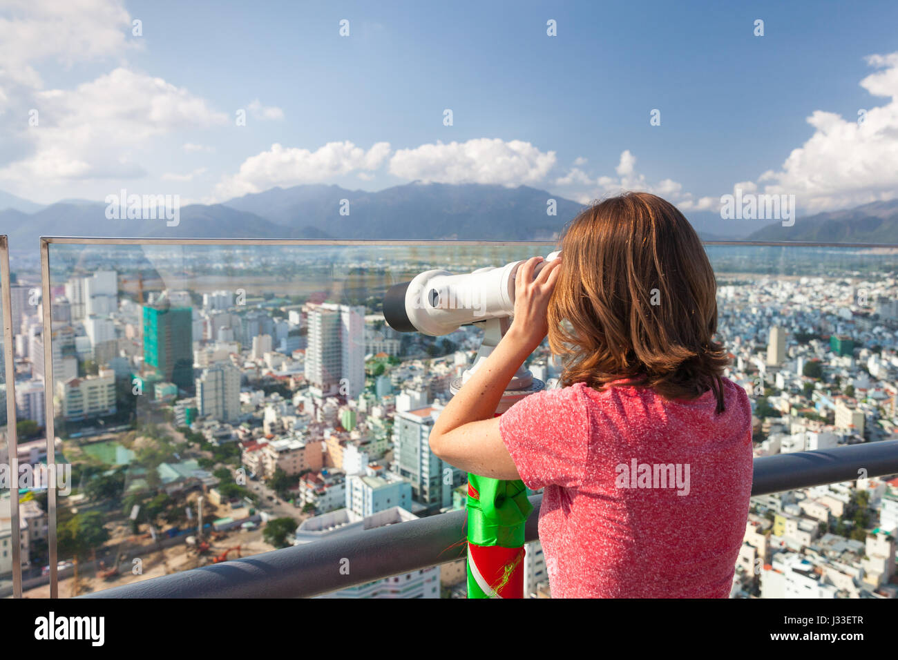 Young woman is looking through the tower viewer Stock Photo - Alamy