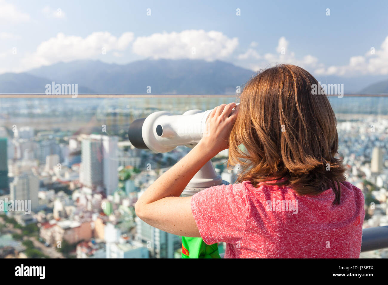 Young woman is looking through the tower viewer Stock Photo - Alamy