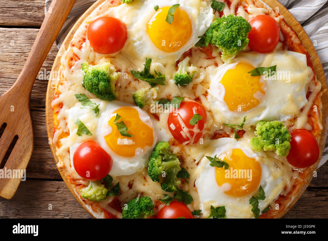 hearty breakfast of pizza with eggs, broccoli, tomatoes and parsley ...